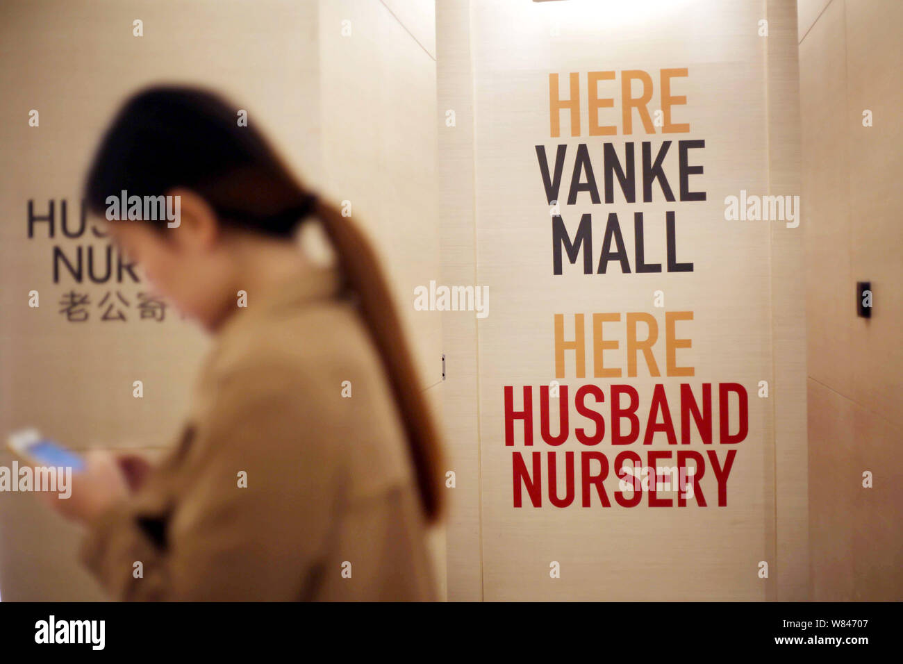 A woman walks past the husband nursery at Vanke Mall in Qibao town ...
