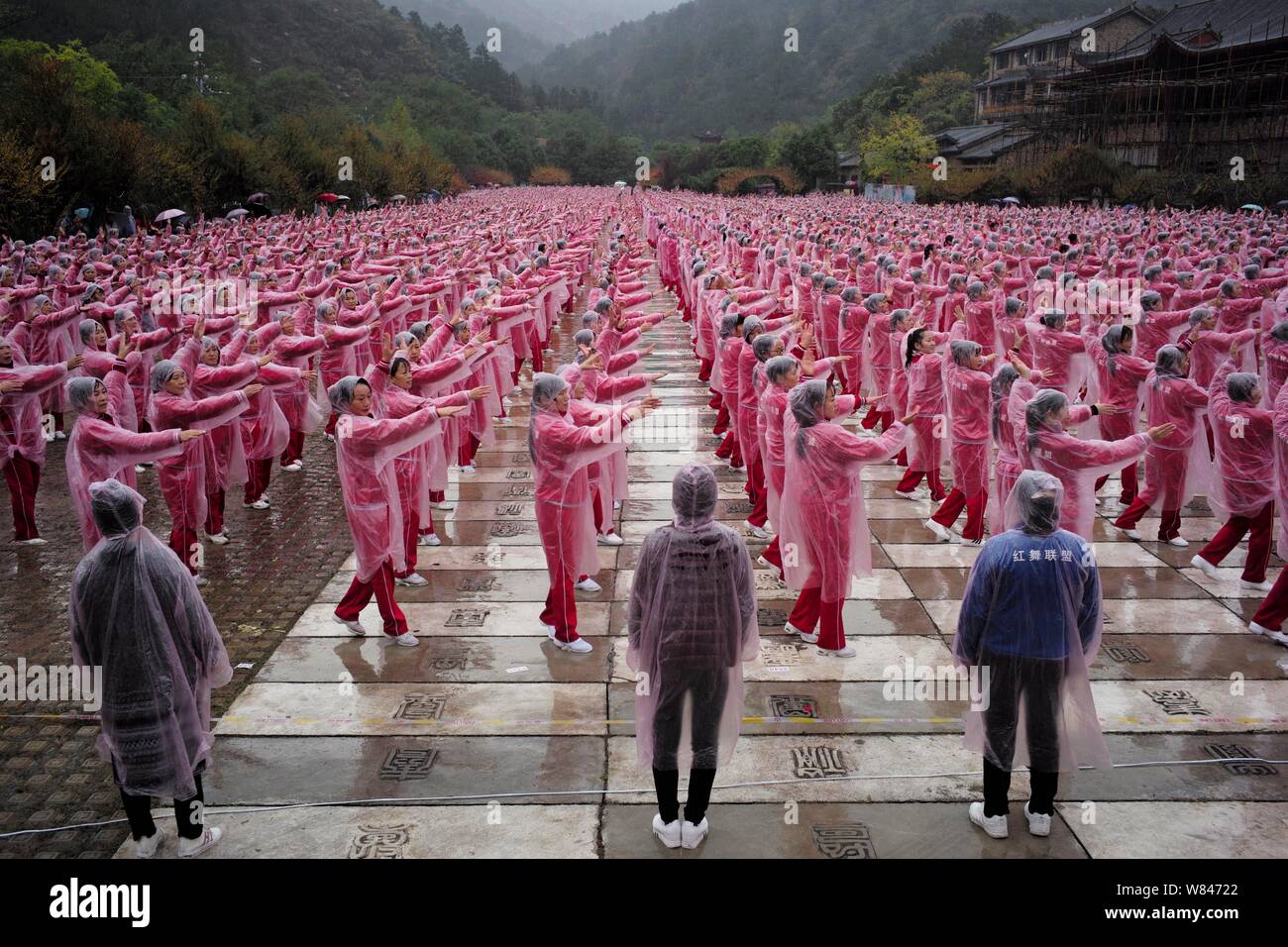 Local Chinese residents wearing raincoats perform square dance in the ...