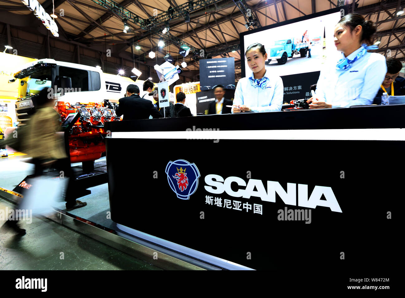 --FILE--Chinese employees are seen at the stand of Scania at the 7th ...