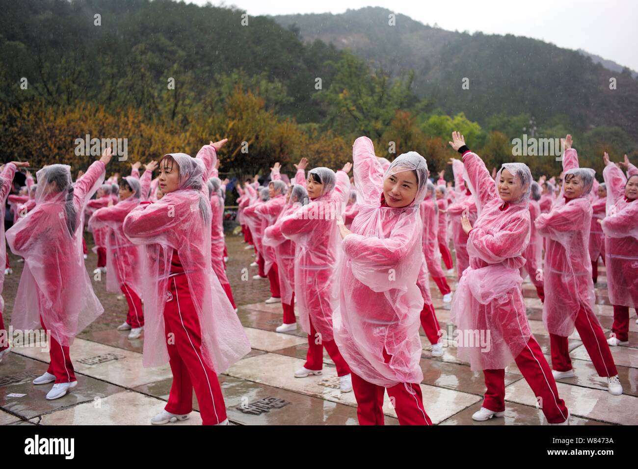 Local Chinese residents wearing raincoats perform square dance in the ...