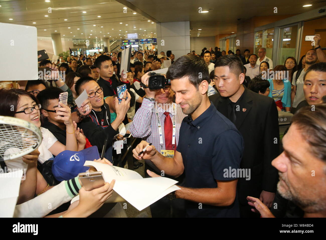 Novak Djokovic of Serbia, center, signs autographs for fans after ...