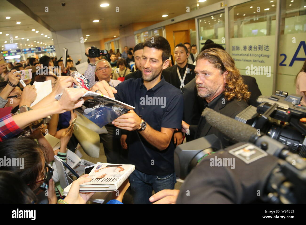 Novak Djokovic of Serbia, center, signs autographs for fans after ...