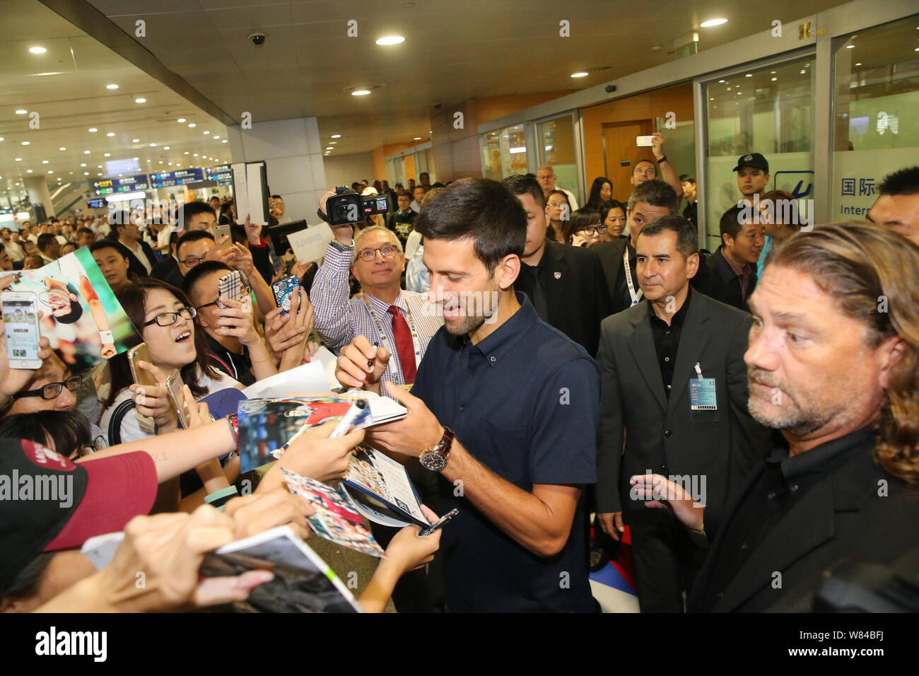 Novak Djokovic of Serbia, center, signs autographs for fans after ...