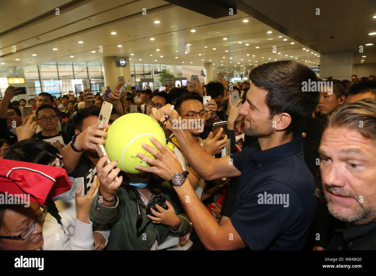 Novak Djokovic of Serbia, center, signs autographs for fans after ...