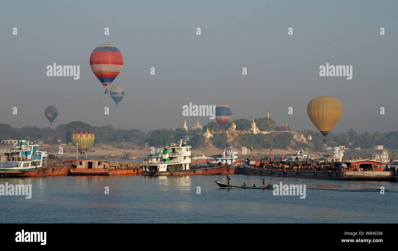 balloons carrying tourists fly over the Irrawaddy river crowded with ...