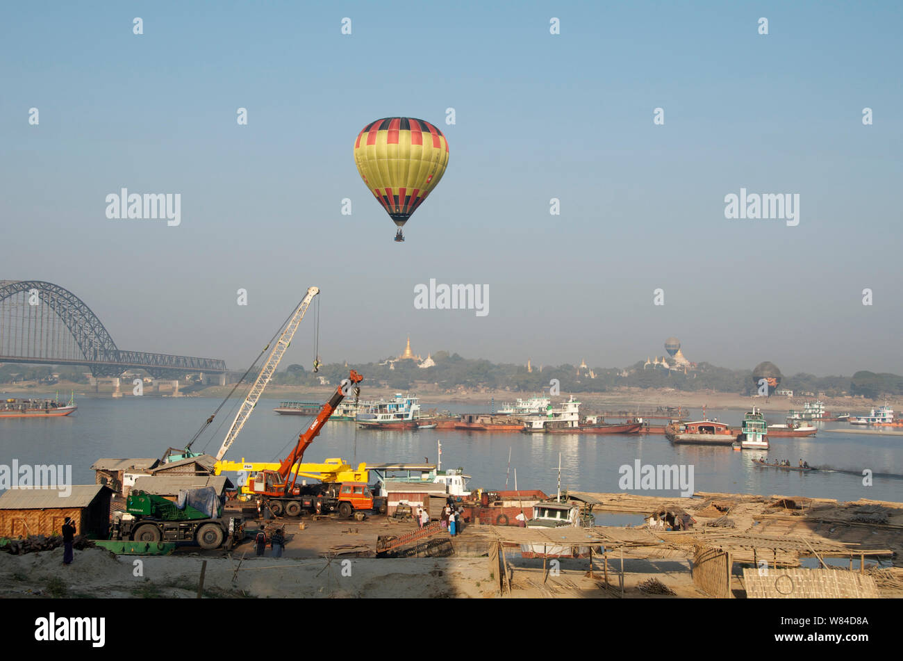 balloons carrying tourists fly over the Irrawaddy river crowded with ...