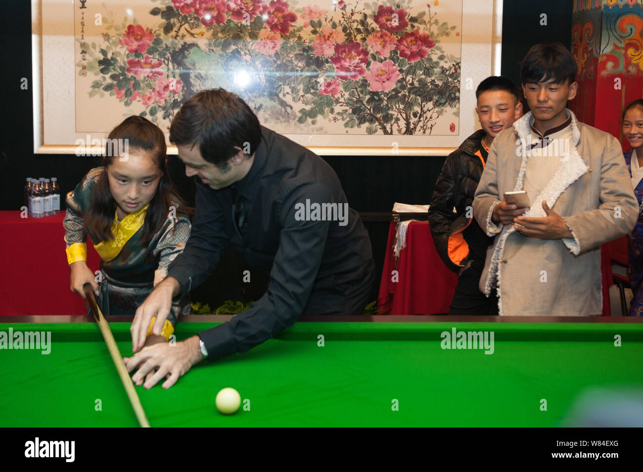 English snooker player Ronnie O'Sullivan, center, instructs a student ...
