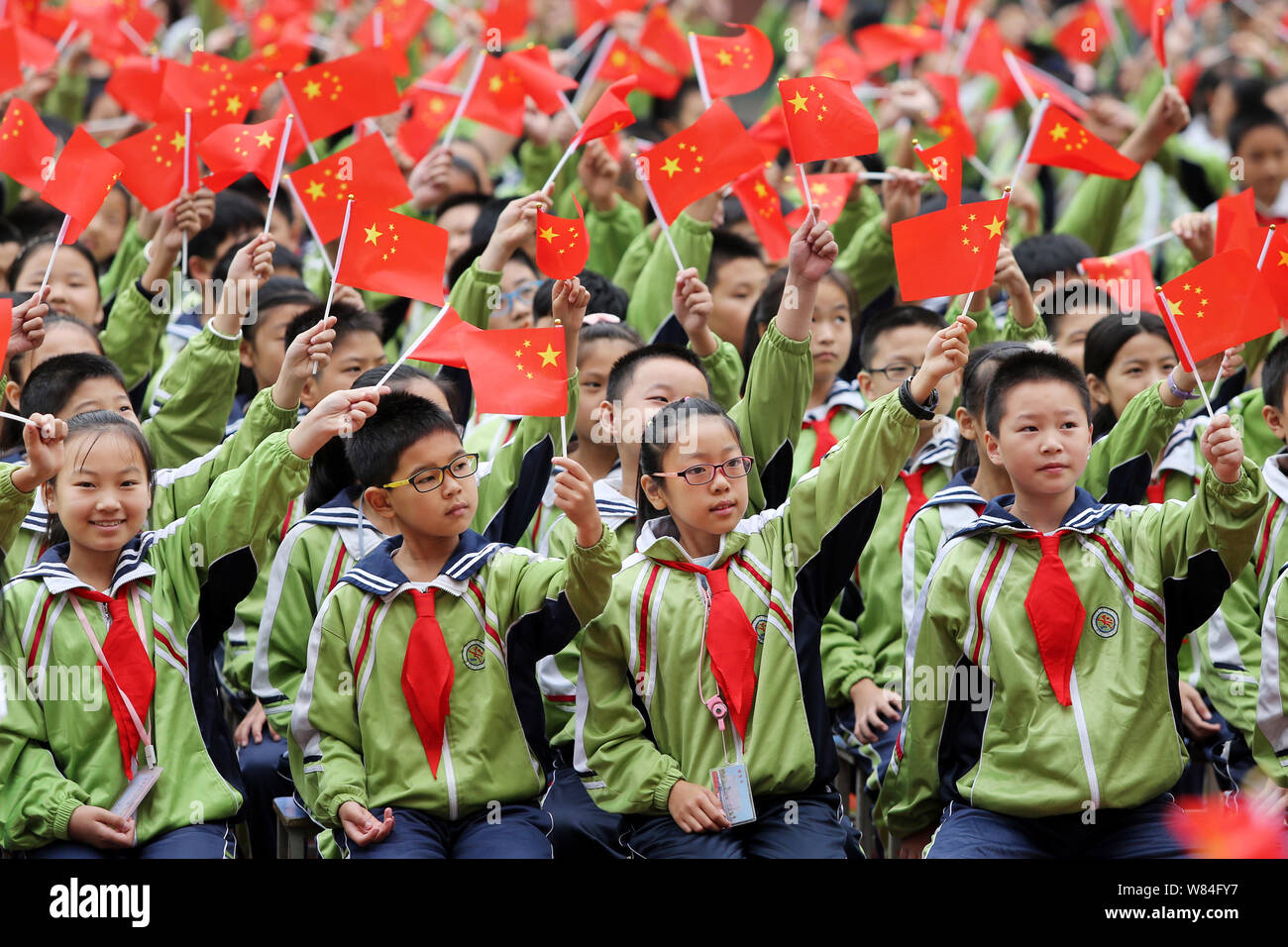 Young Chinese students wave national flags during a gala to celebrate ...