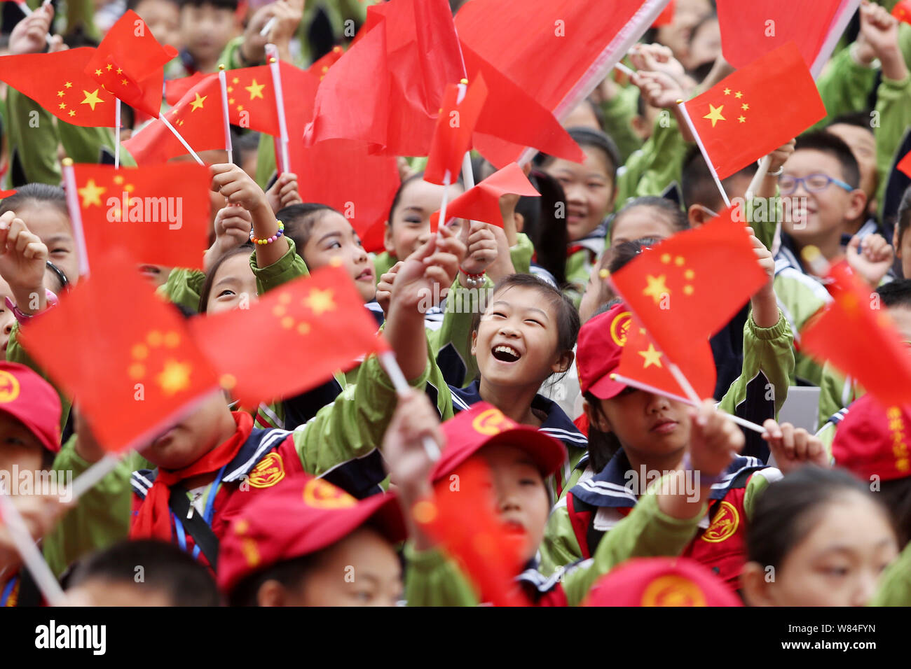 Young Chinese students wave national flags during a gala to celebrate ...