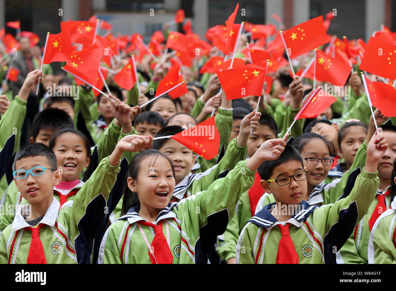 Young Chinese students wave national flags during a gala to celebrate ...