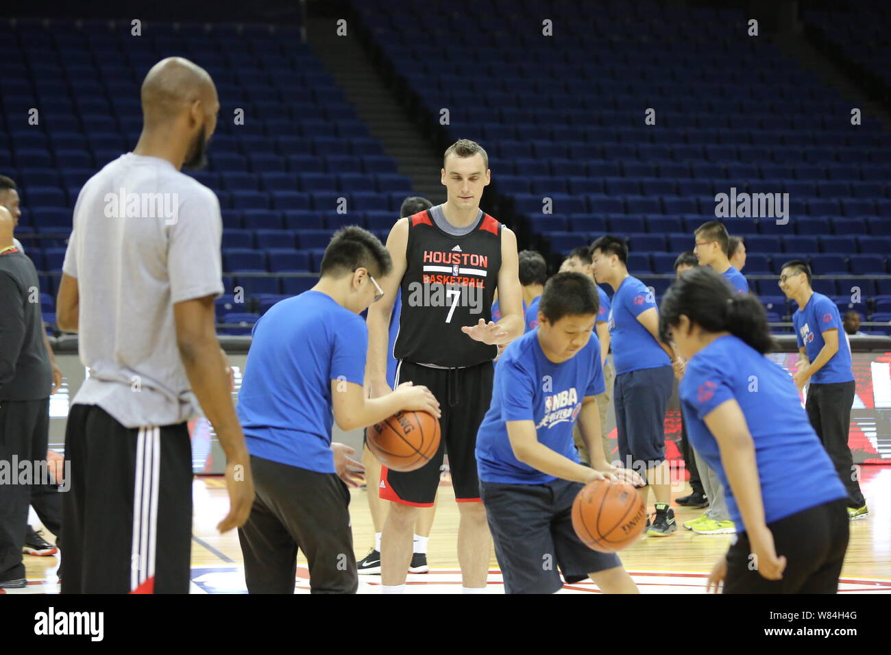 Sam Dekker of Houston Rockets, center, instructs young fans to play ...