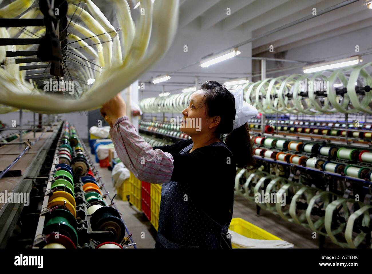--FILE--A female Chinese worker handles production of yarn at a textile factory in Haian county ...