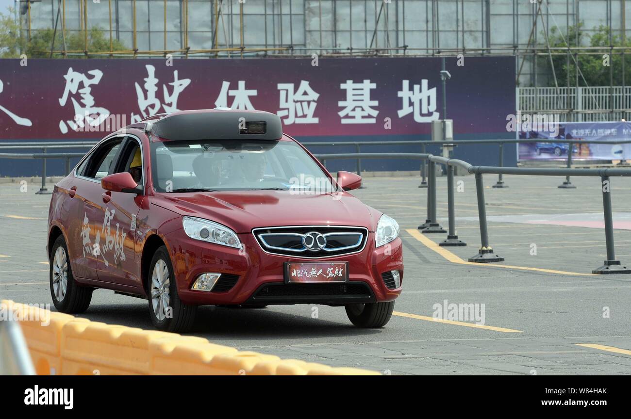 --FILE--Visitors try out a self-driving car of BAIC Group during the ...