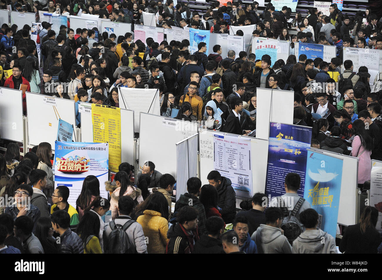 Chinese graduates and students crowd booths of recruiters during a job ...