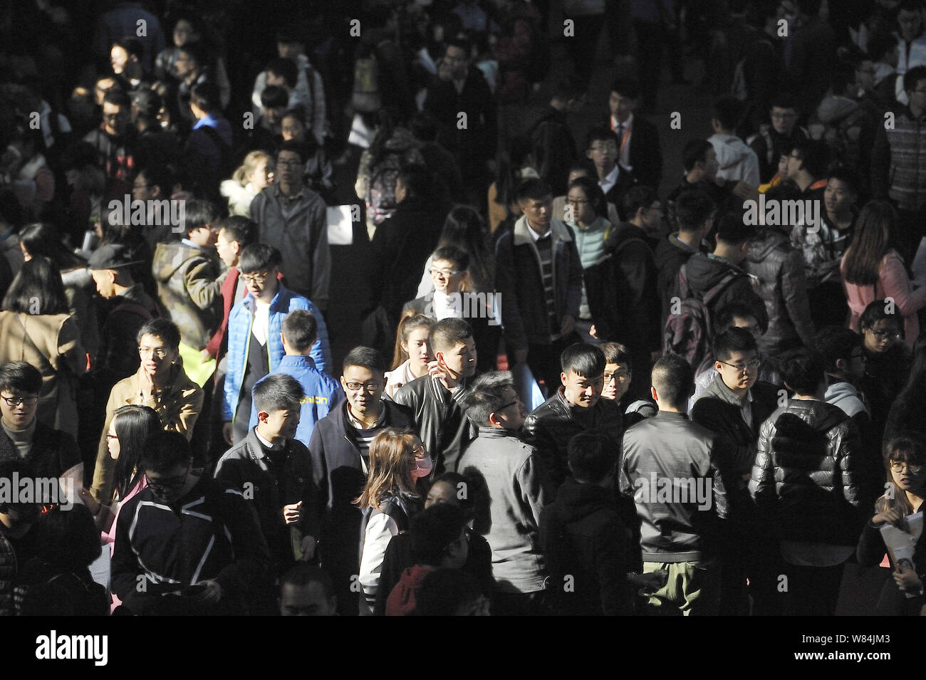 Chinese graduates and students crowd a job fair at a university in ...