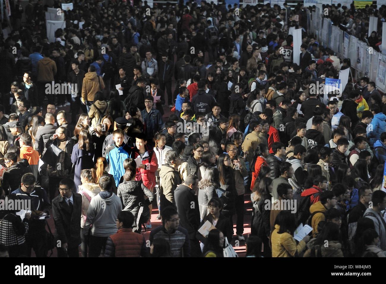 Chinese graduates and students crowd booths of recruiters during a job ...