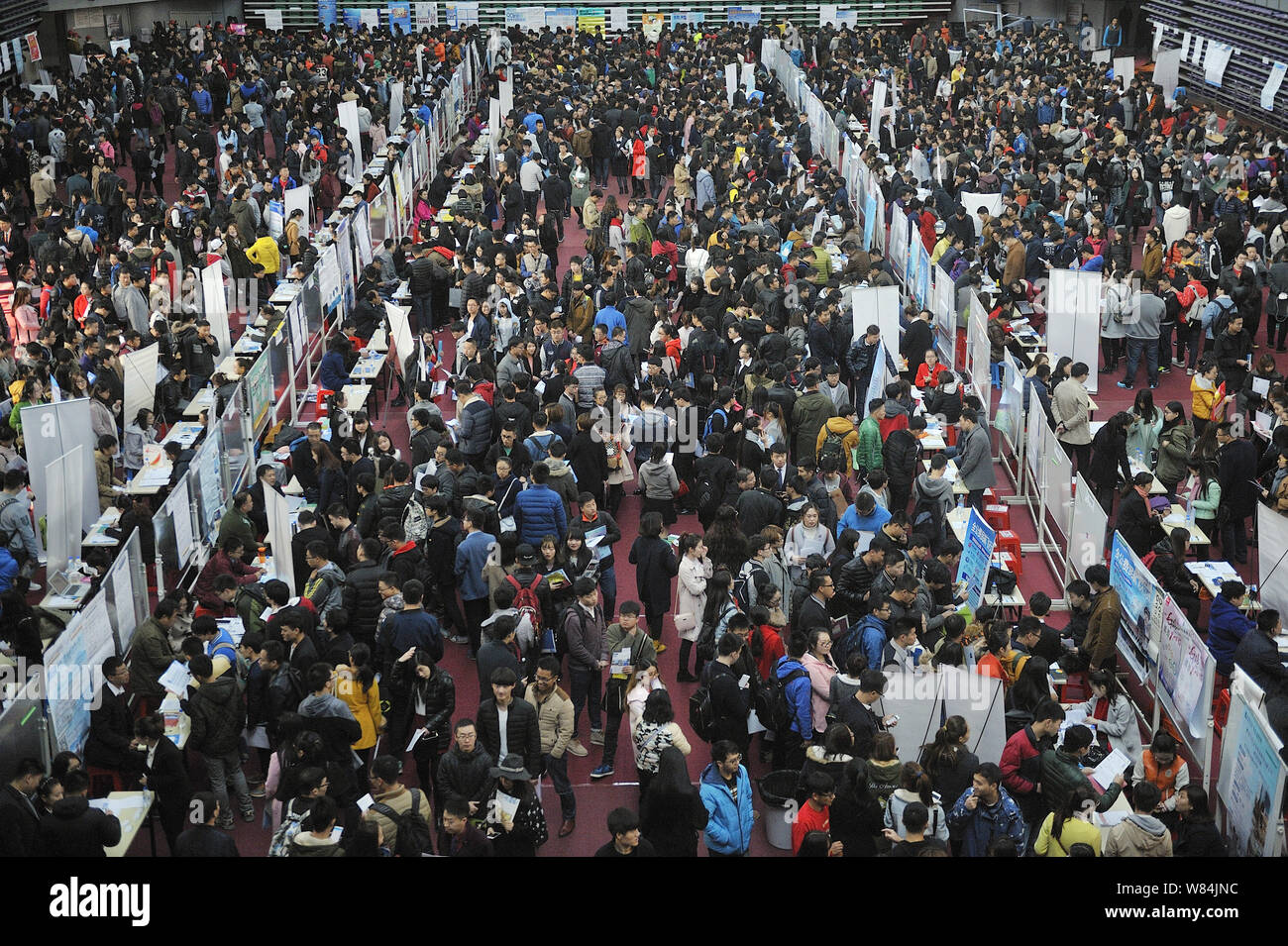 Chinese graduates and students crowd booths of recruiters during a job ...