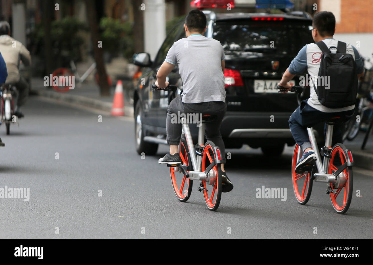 --FILE--Cyclists ride bicycles of Chinese bike-sharing service MoBike ...