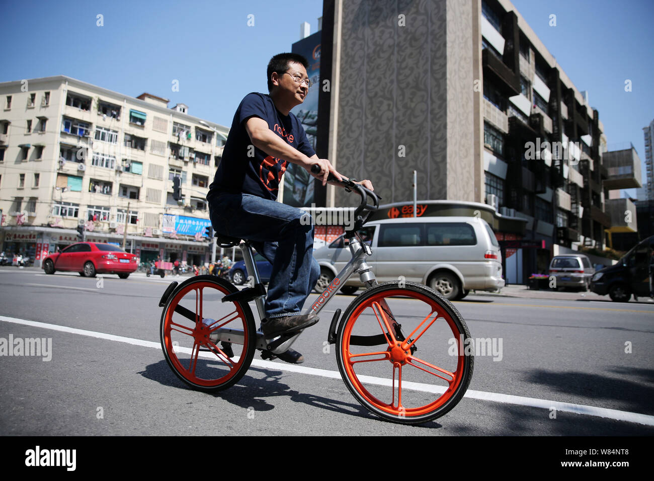 --FILE--Wang Xiaofeng, Founder and CEO of Chinese bike-sharing service Mobike, ride a bicycle of ...