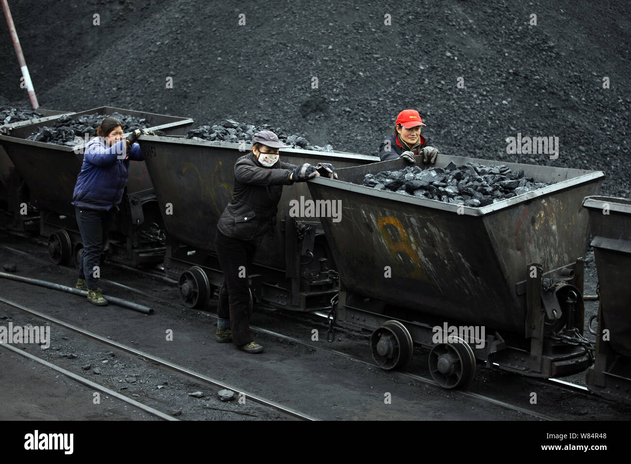 --FILE--Female Chinese workers push mine cars loaded with coal at a ...