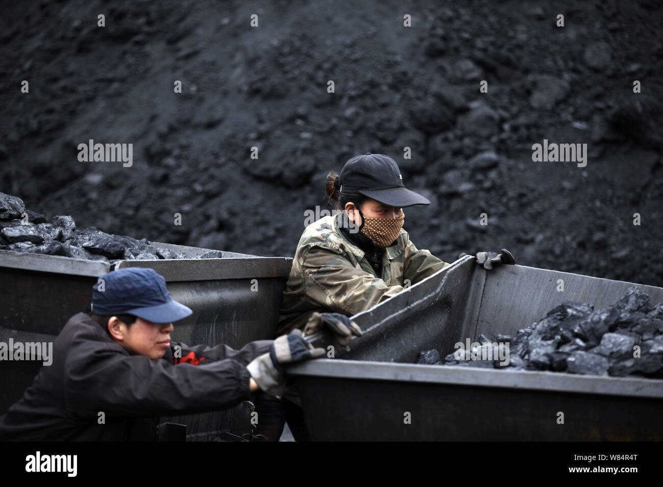 --FILE--Female Chinese workers push mine cars loaded with coal at a ...