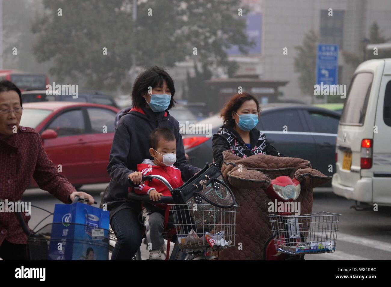 Chinese cyclists wearing face masks against air pollution ride on the ...