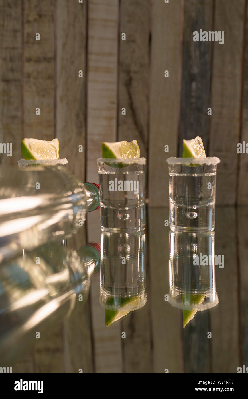 Luxurious tequila - Bottle of tequila in front of three shots of tasty ...