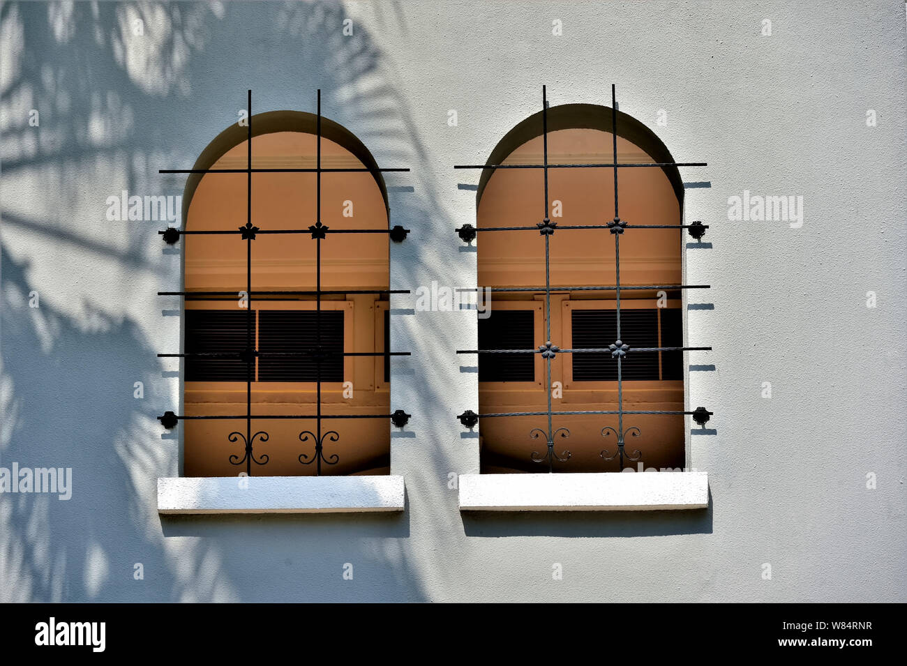 Pair of arched Arabic style windows with metal grills on the yellow ...