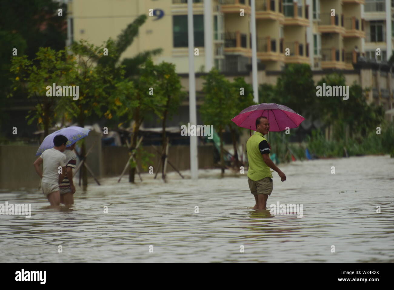 Pedestrians walk on a flooded road after heavy rain caused by Typhoon ...