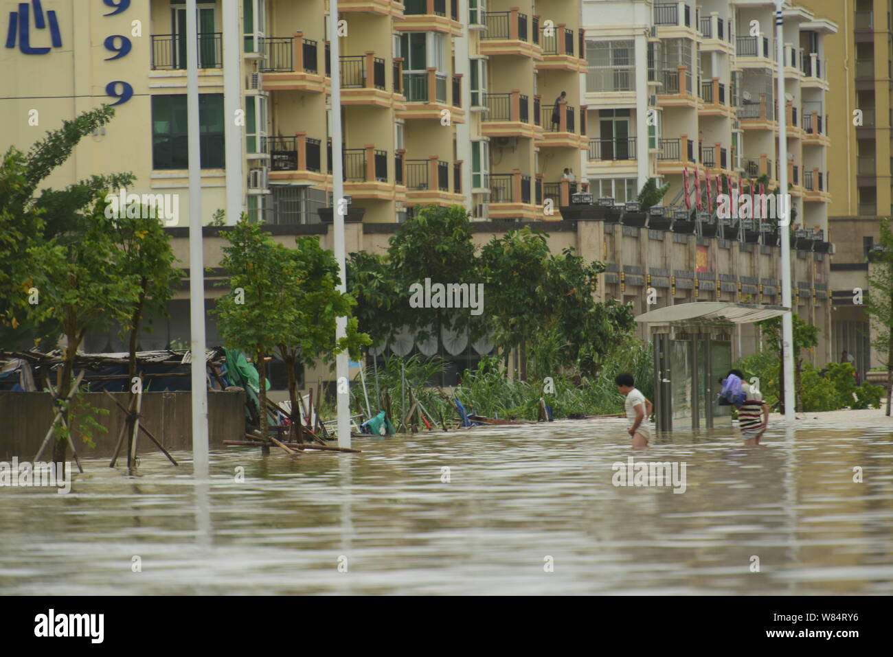 Pedestrians walk on a flooded road after heavy rain caused by Typhoon ...