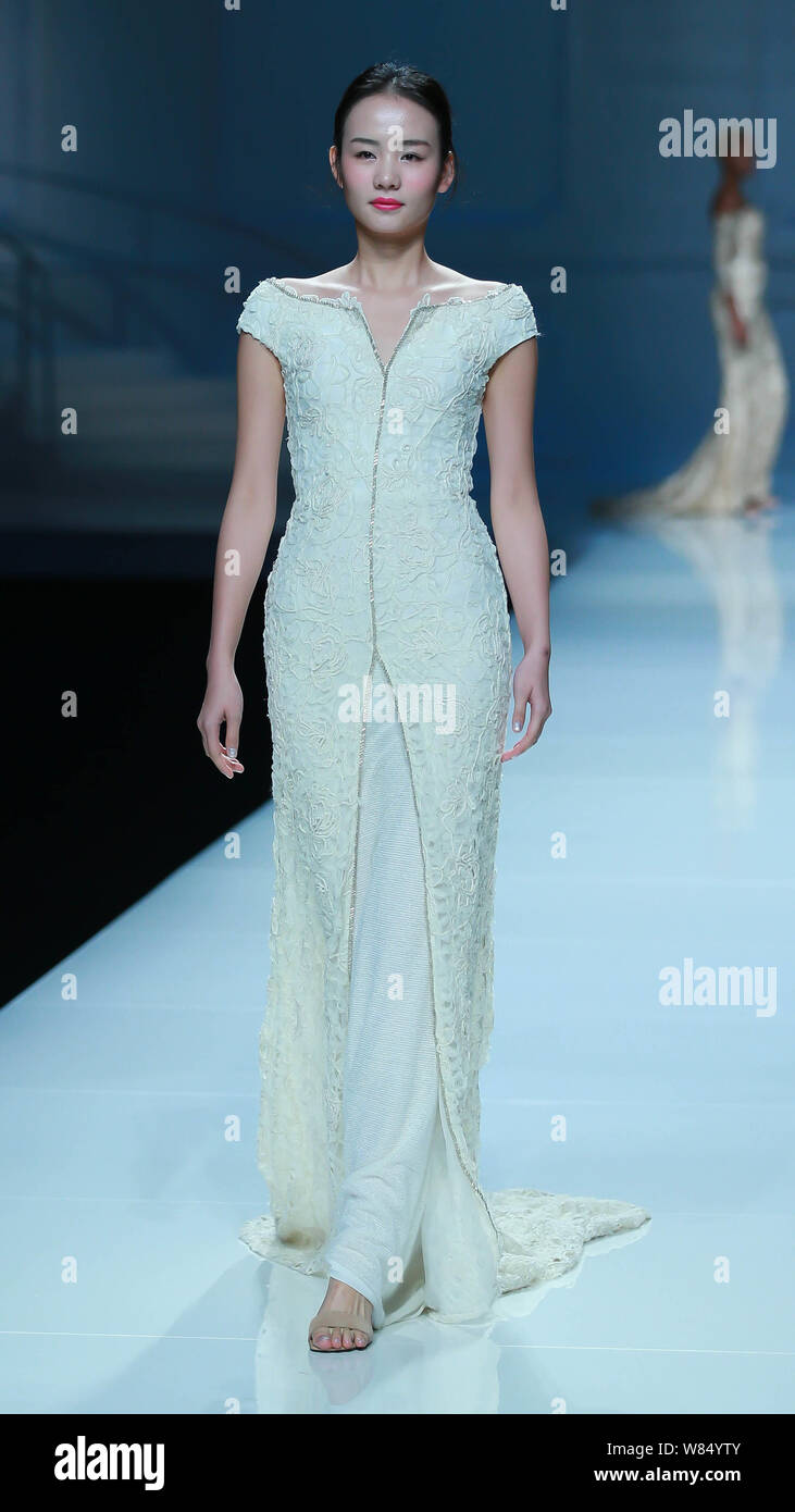 A model displays a new creation at a fashion show of SNOW LOTUS by Tanya Wang during the China ...