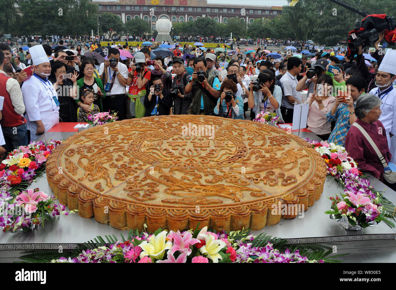 Visitors take photos of the world's largest lily mooncake during an ...