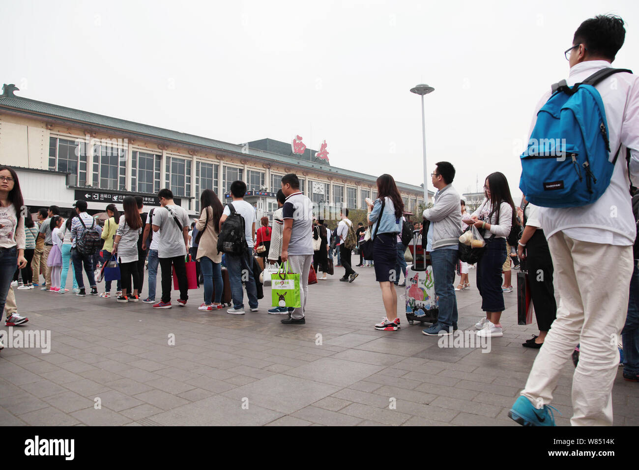 Chinese passengers queue up in front of the Xi'an Railway Station ...