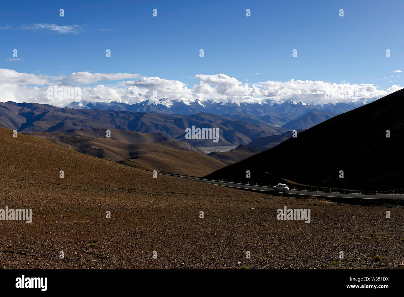 A car travels on the road from the county seat of Tingri to Tashi Dzom ...