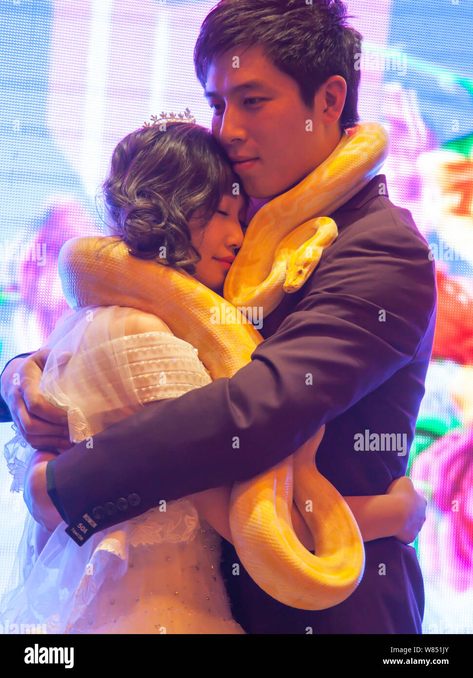 Chinese groom Wu Jianfeng hugs his bride Jiang Xue while carrying ...