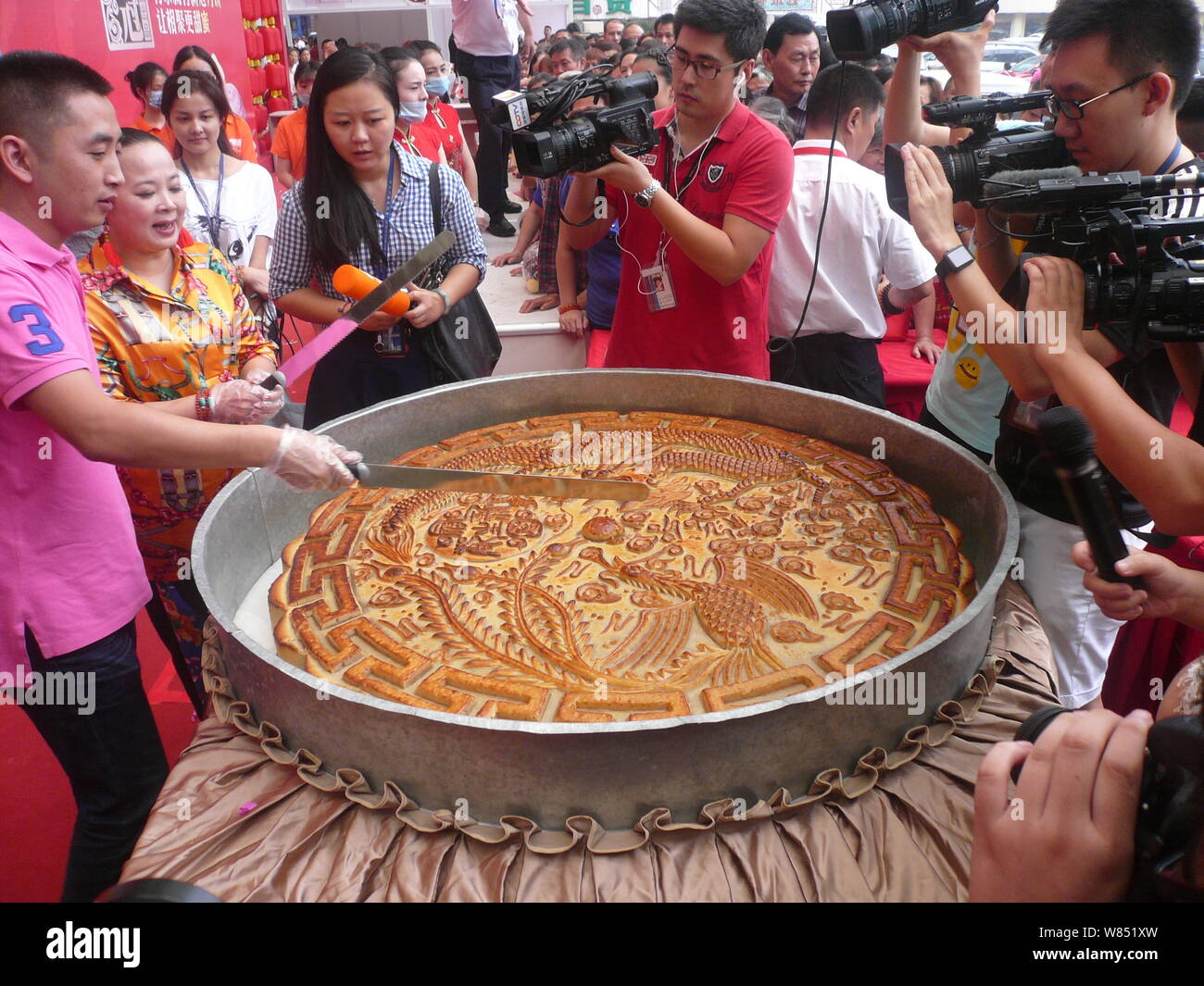 Visitors share a giant mooncake with a diameter of 1.4 meters during a ...