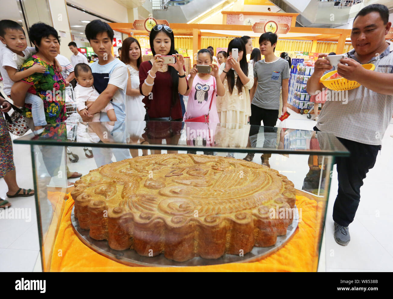Customers take photos of a giant mooncake with a diameter of 80 ...