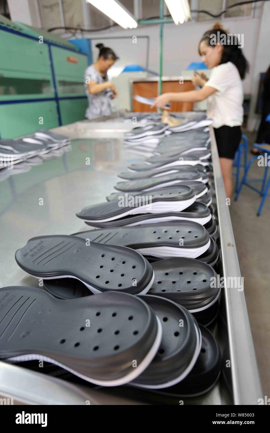 --FILE--Chinese workers make soles of sports shoes at a factory in ...