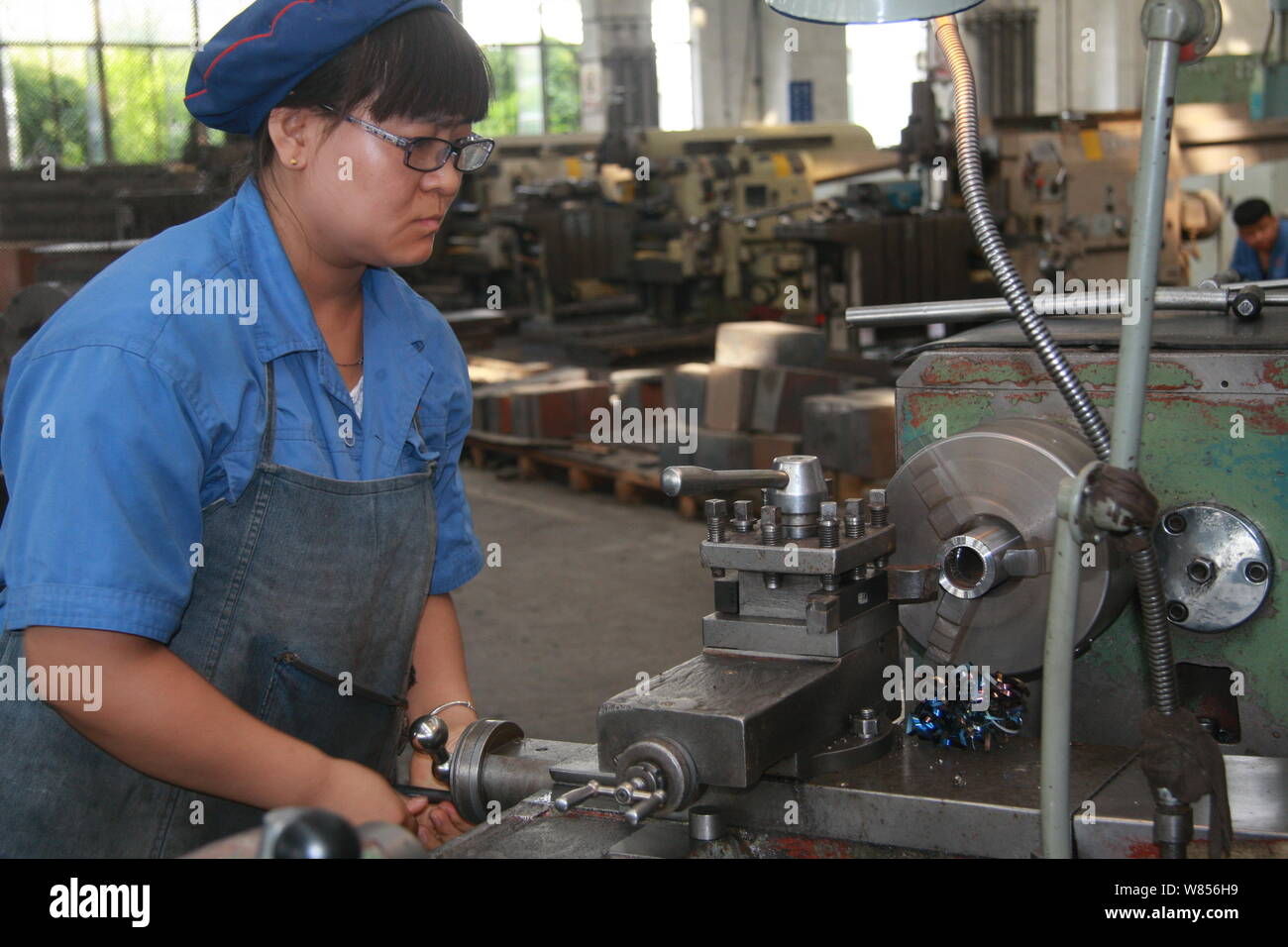 --FILE--A worker operates a machine at Tianshui Metalforming Machine ...