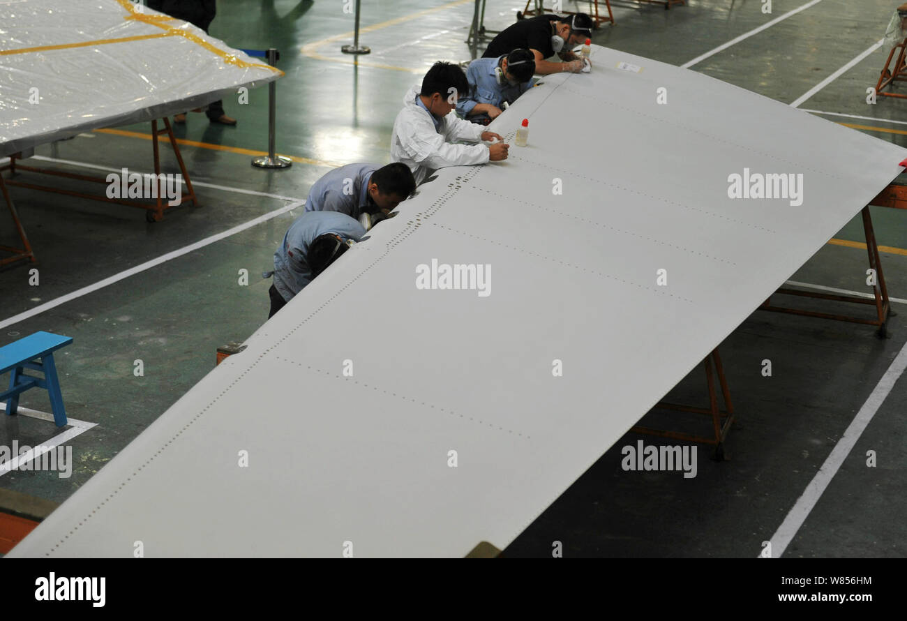 Chinese workers examine the first rudder during the delivery ceremony ...