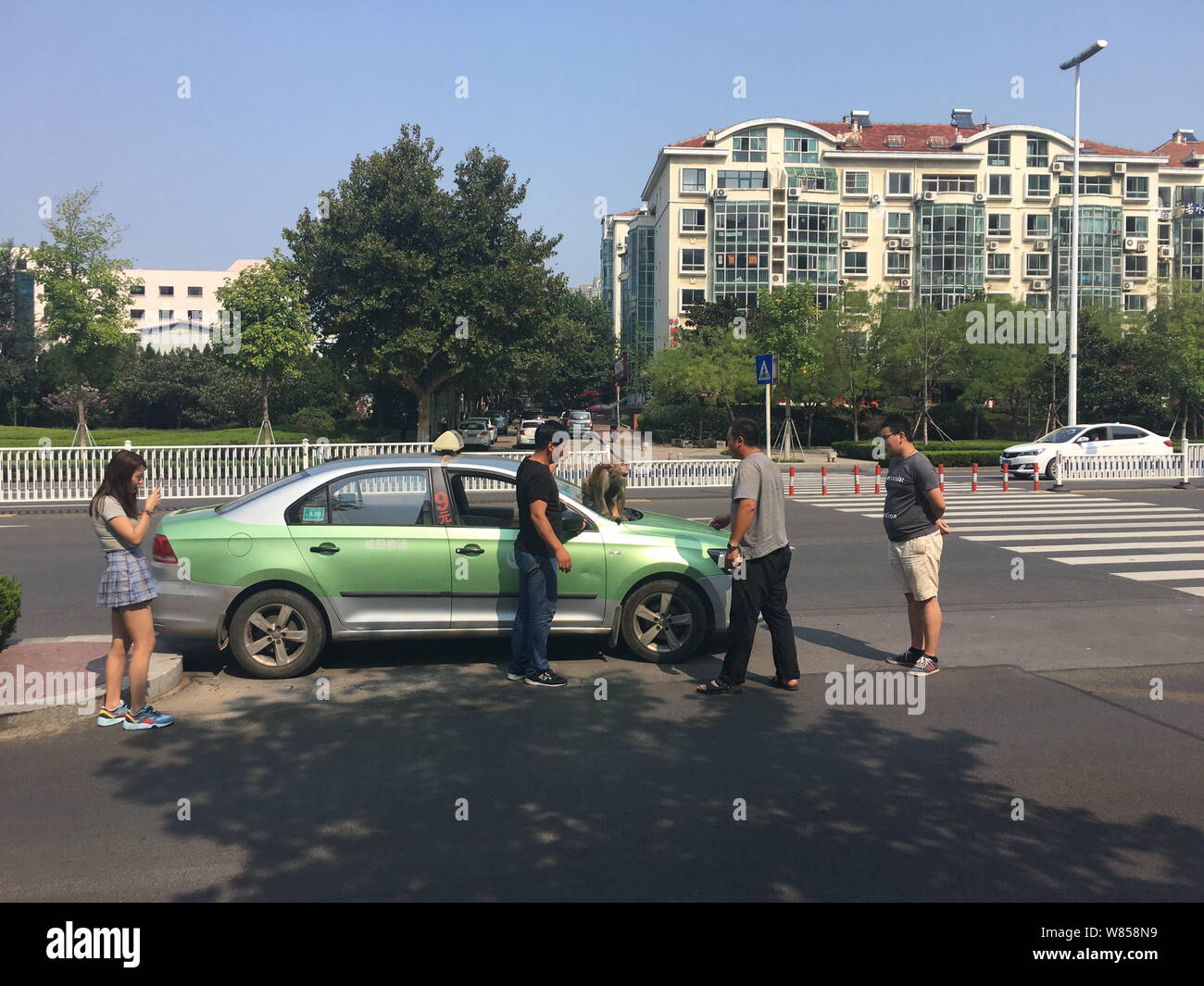 A ringmaster of a circus, second left, carrying a monkey, talks with a ...