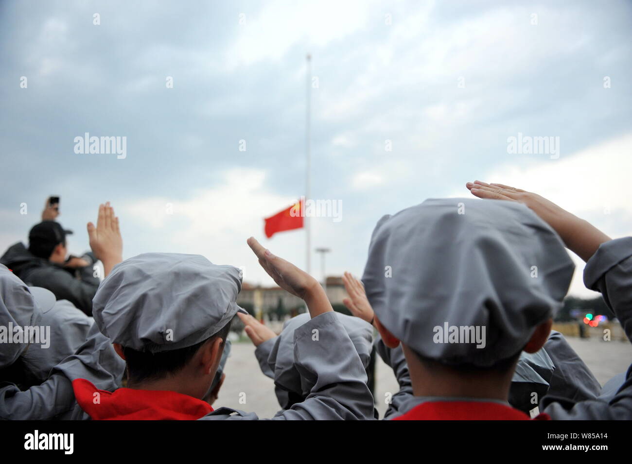 Chinese pupils dressed in "Red Army" costumes salute during a flag ...