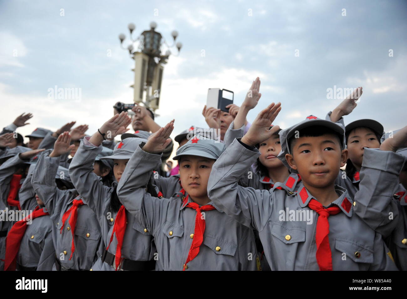 Chinese pupils dressed in "Red Army" costumes salute during a flag ...