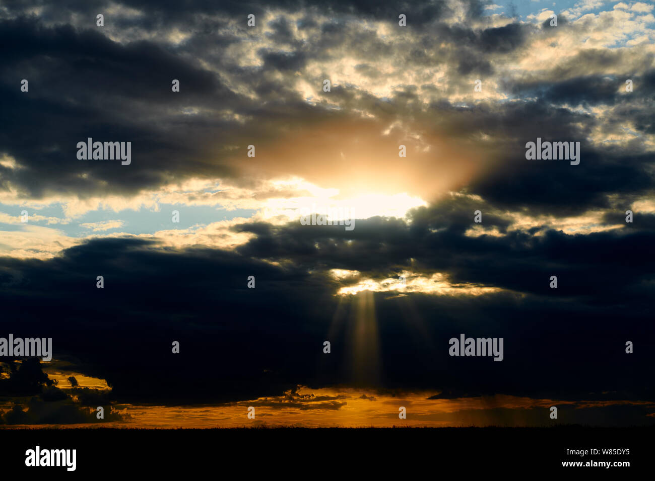 Beautiful sunset - dark sky with clouds and sunlight Stock Photo - Alamy