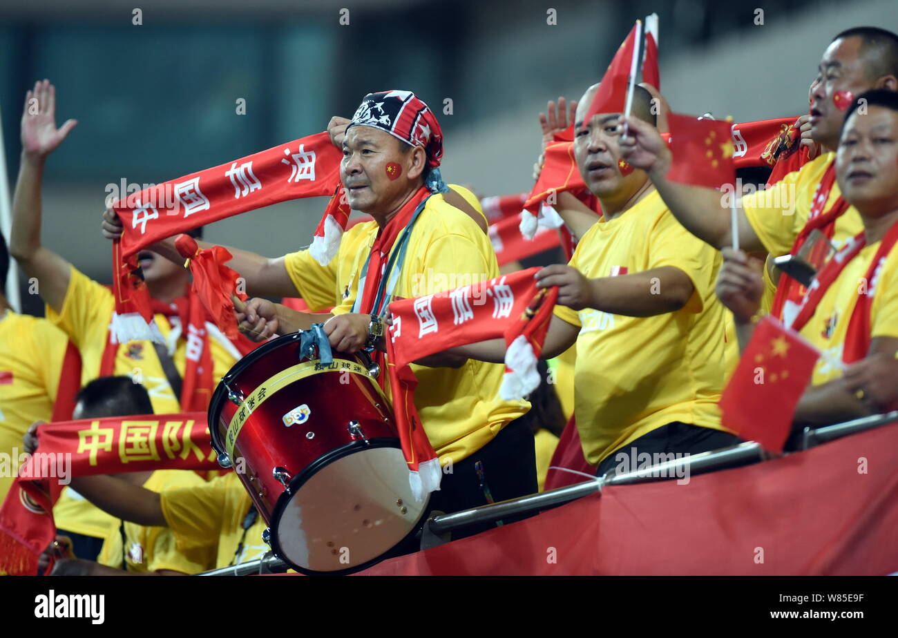 Chinese football fans wave national flags, display banners and shout ...