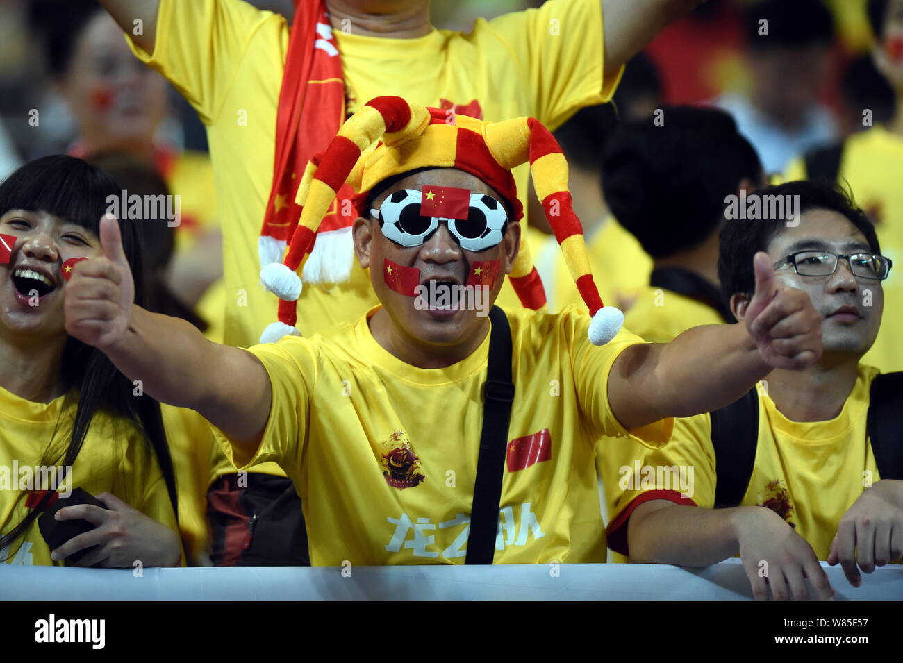 Chinese football fans cheer to show support for the China team during a ...