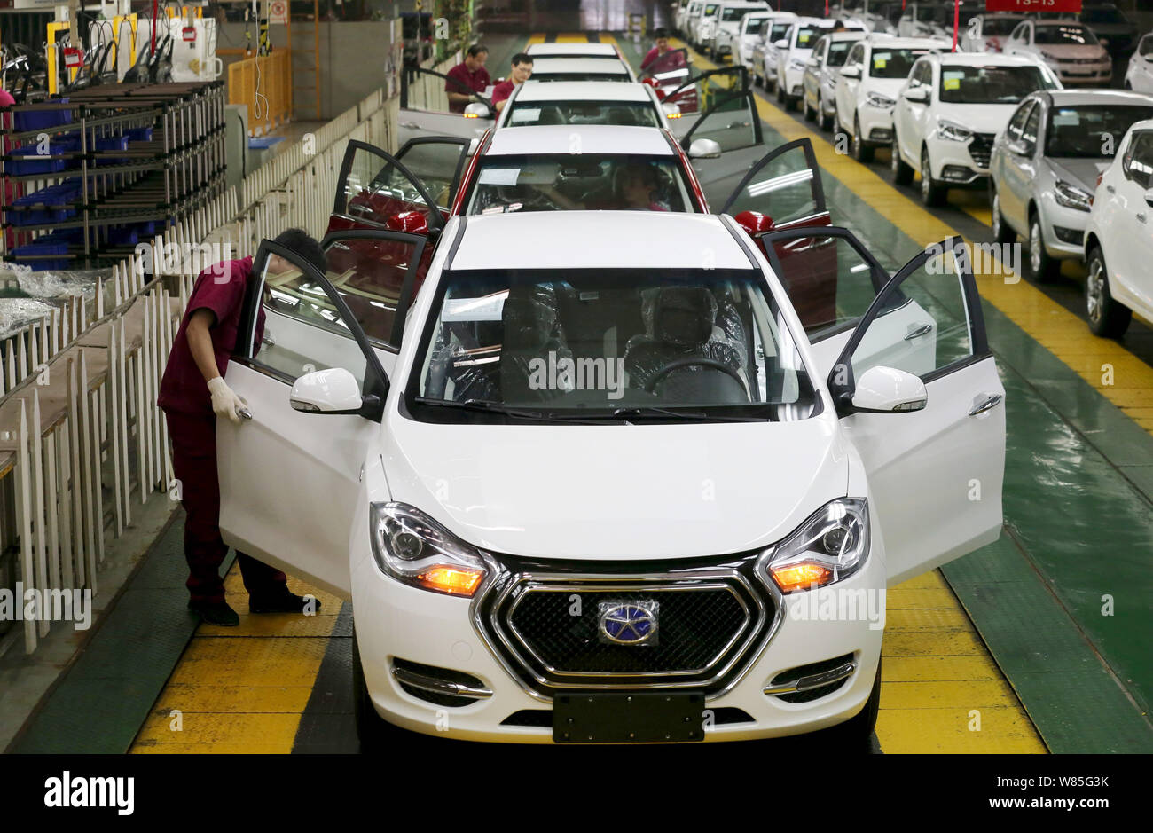 --FILE--Chinese factory workers check new cars on the assembly line at ...