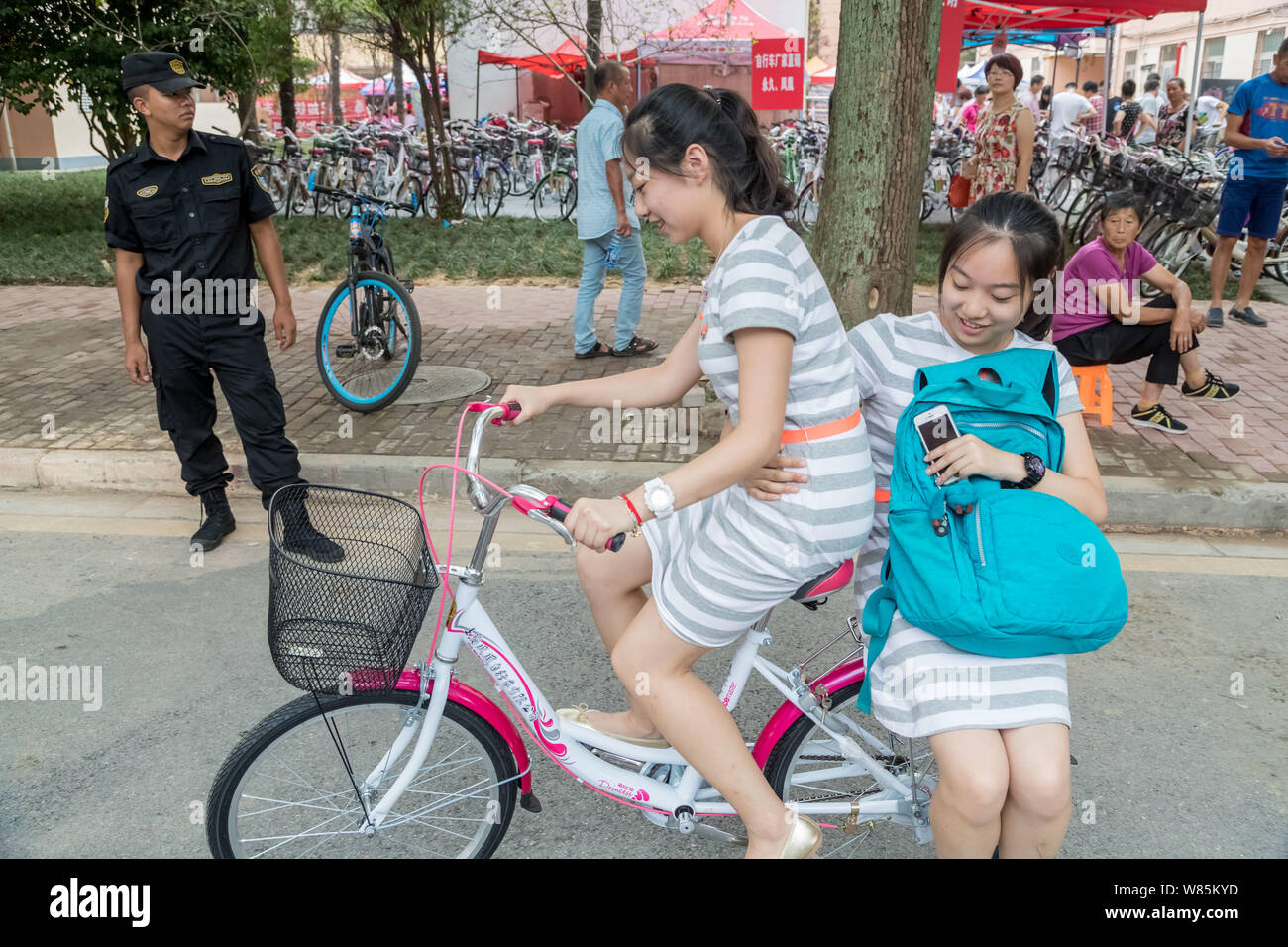Chinese twin girls Jiang Yichun and Jiang Yijie ride a bicycle in the ...