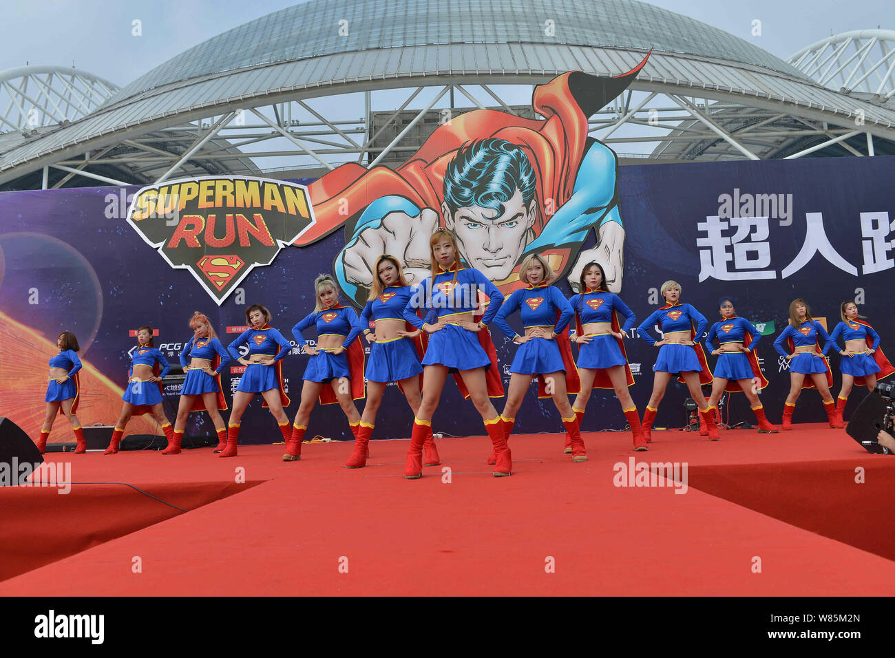 Female dancers dressed in costumes of Superman perform during the ...