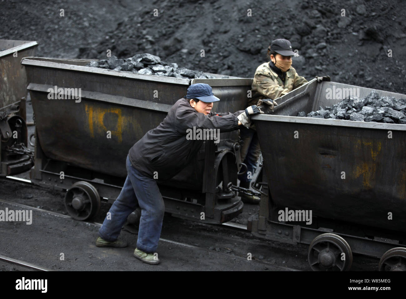 --FILE--Female Chinese workers push mine cars loaded with coal at a ...